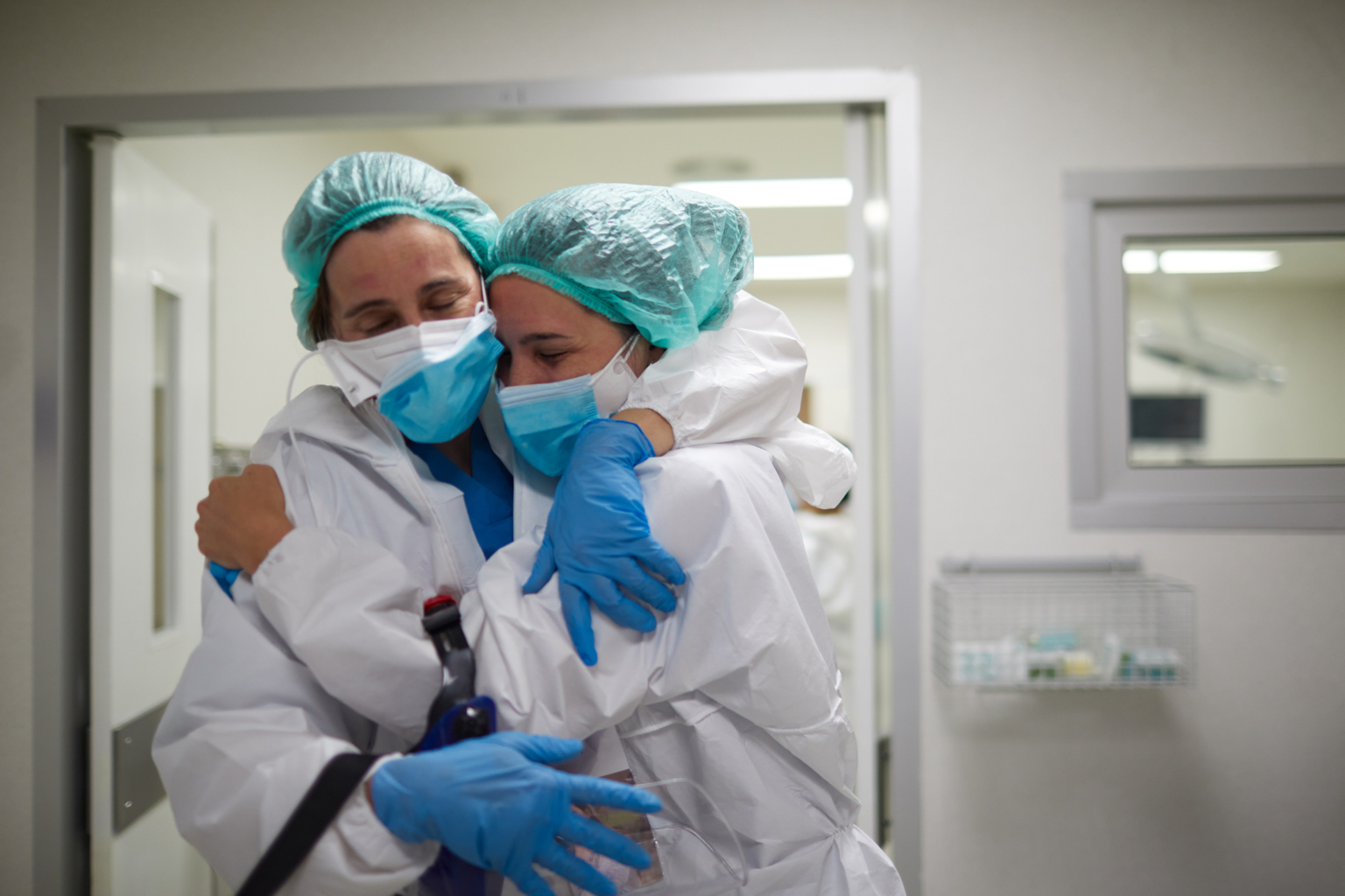 Two healthcare workers hug in celebration of a successful surgery ...
